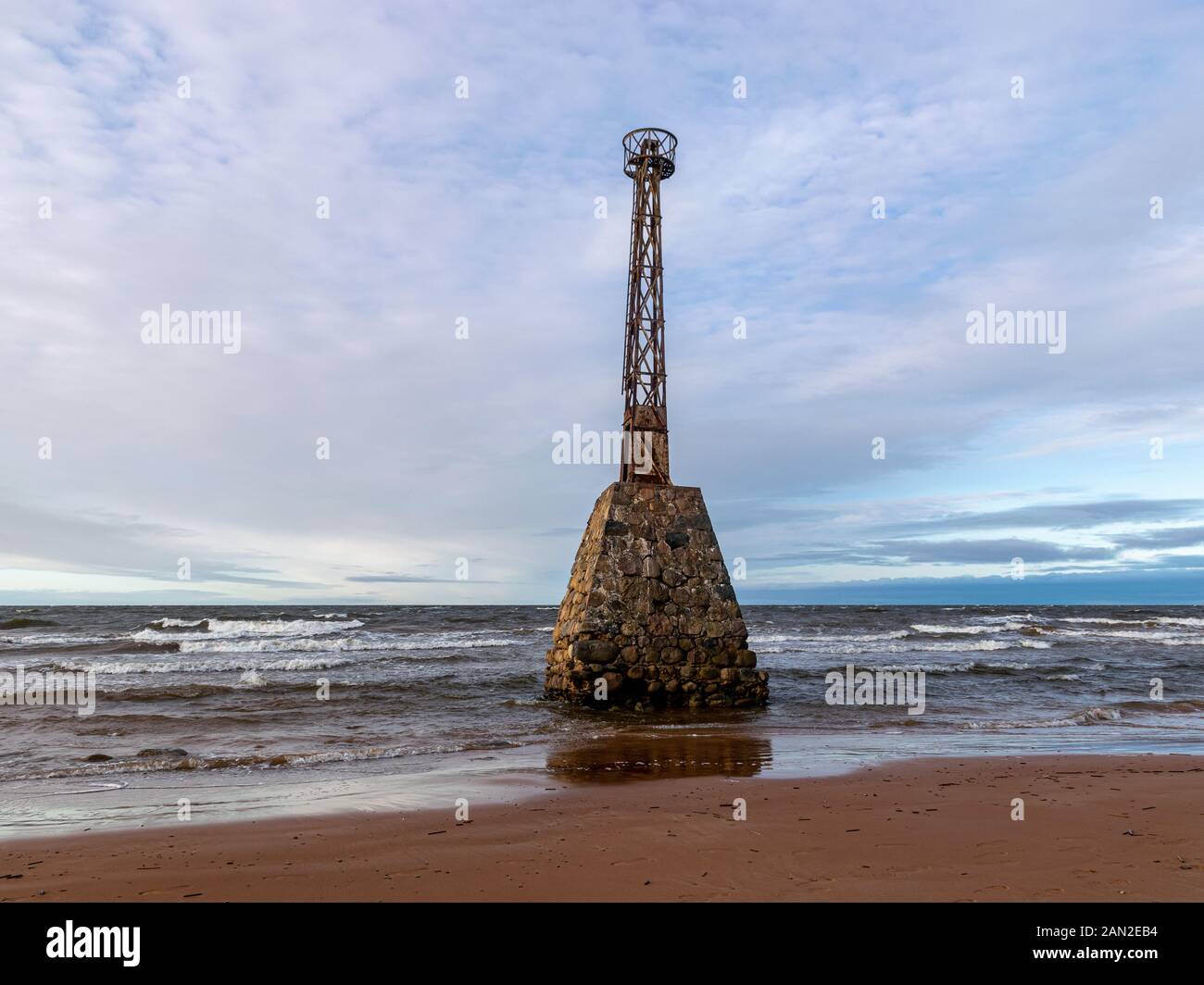 landscape with old and crooked lighthouse by the sea, windy day by the ...