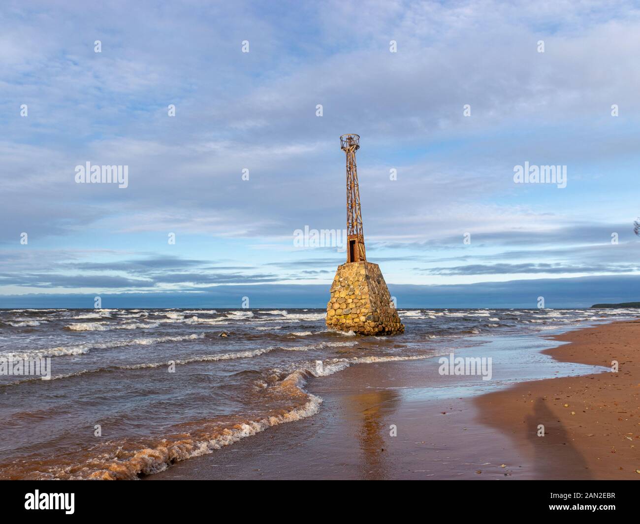 landscape with old and crooked lighthouse by the sea, windy day by the ...