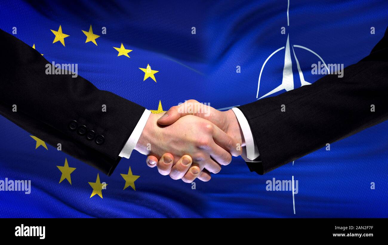 European Union and NATO handshake, international friendship, flag ...