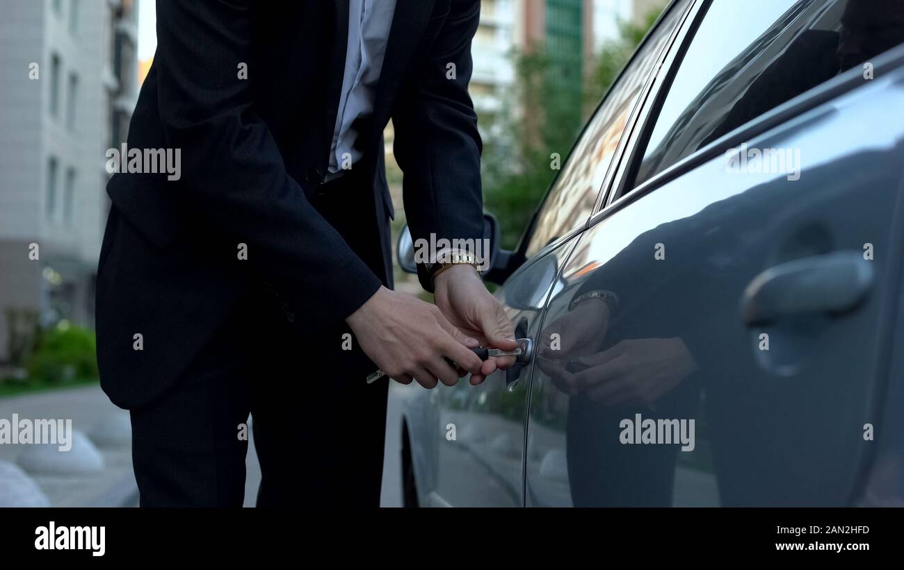 Tired business person locking car with keys, returning home from work ...