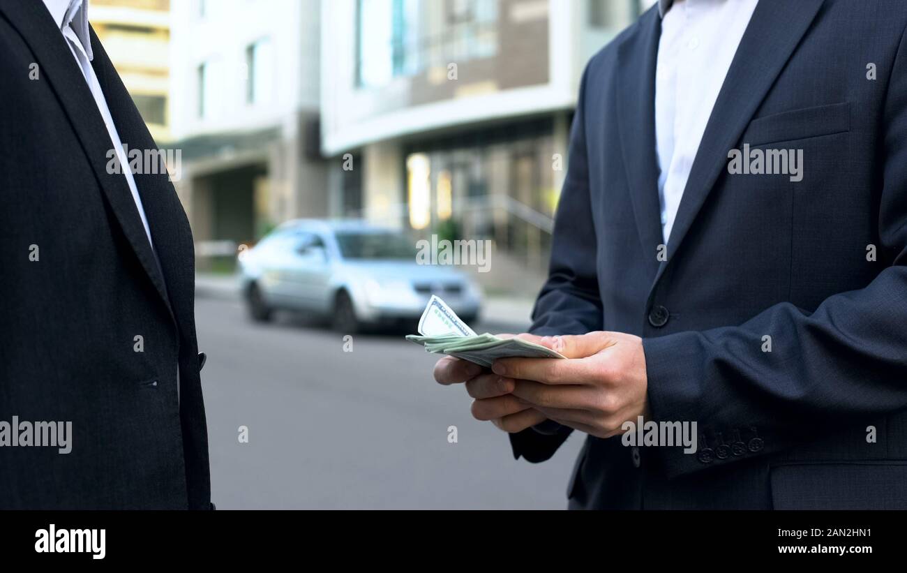 Two office workers counting money outside business centre, week salary ...