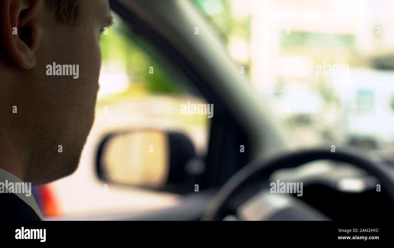 Young businessman driving car in city traffic, going to office meeting ...