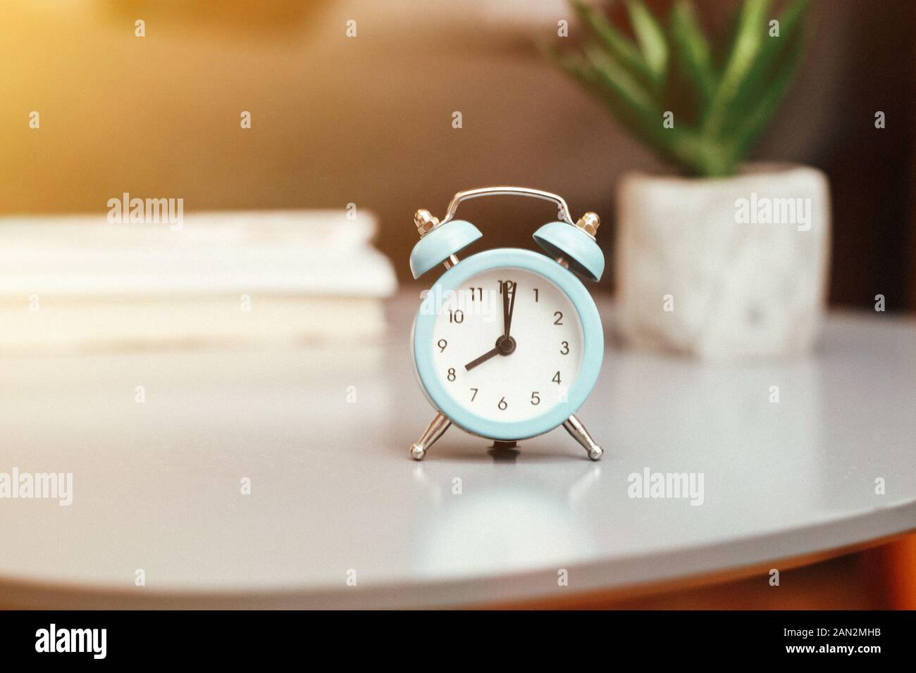 Alarm clock on blurred bedroom background in the morning, interior ...