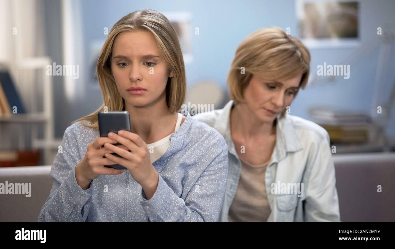 Mom trying to talk to teenage child at home, relations problem, phone ...