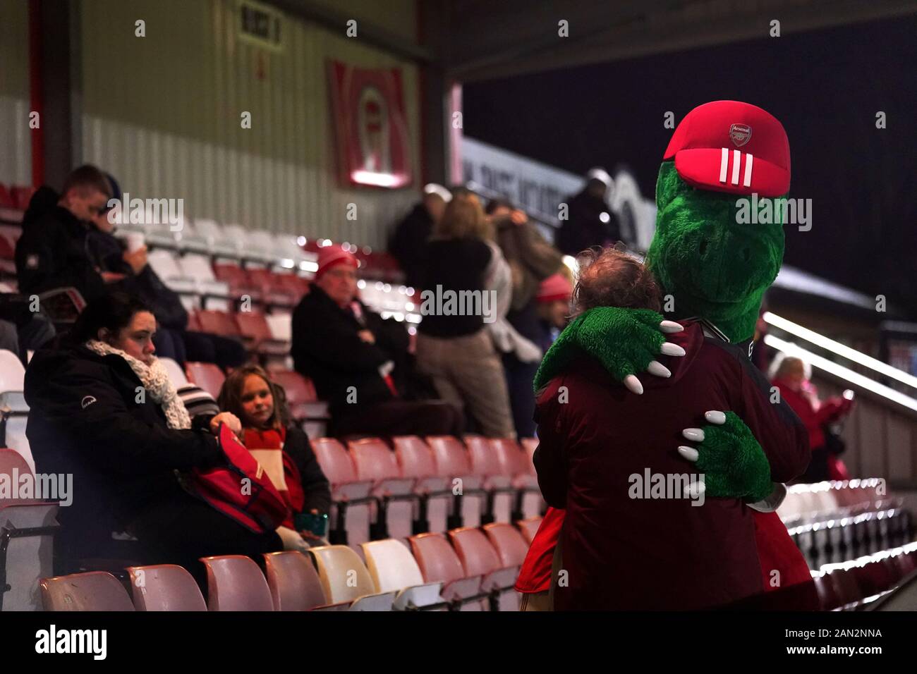 A fan embraces Arsenal mascot Gunnersaurus before the Continental Cup ...