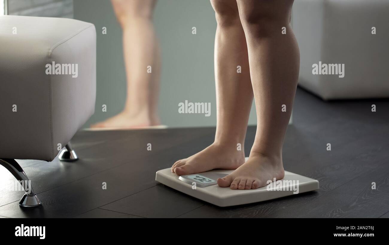 Woman standing on scales to see result of healthy dieting, normal ...