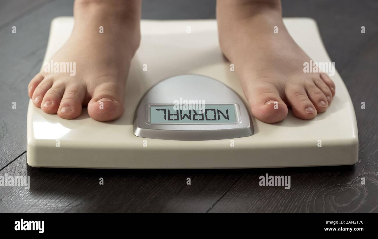 Normal weight, woman standing on scales to check diet results, front ...