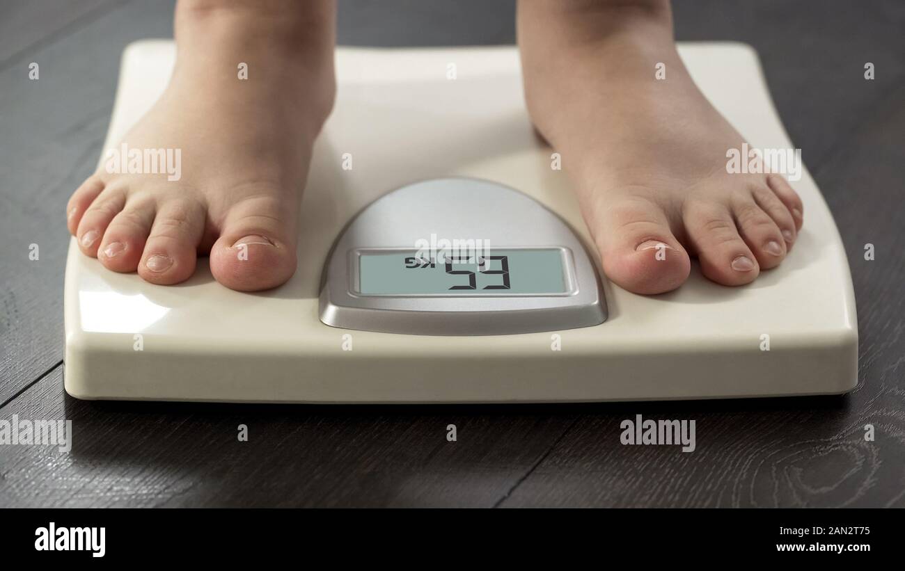 Female standing on scales to see weight control result, healthy dieting ...