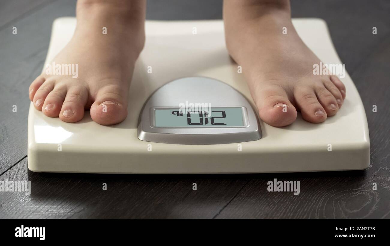 Obese woman standing on scales to check body weight, overweight problem ...
