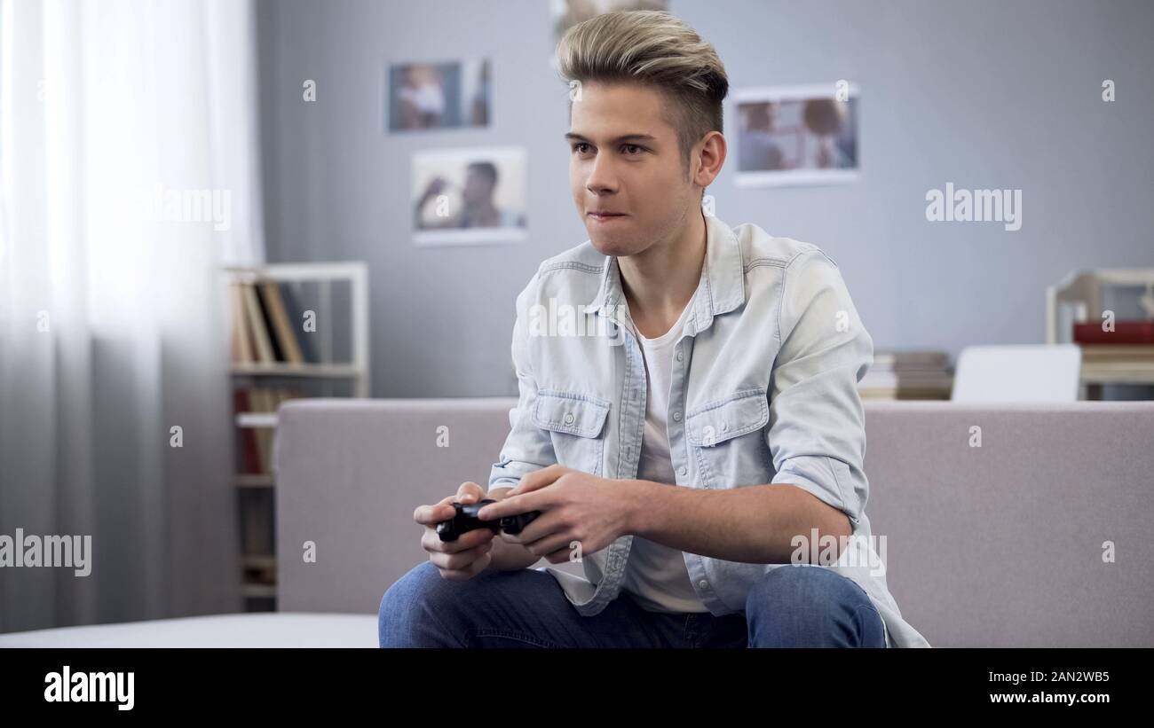 Guy playing computer game with controller, worried about winning ...