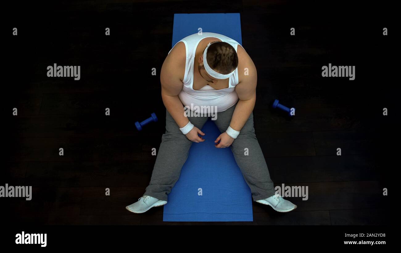 Tired obese male resting after dumbbells exercise, ineffective training ...