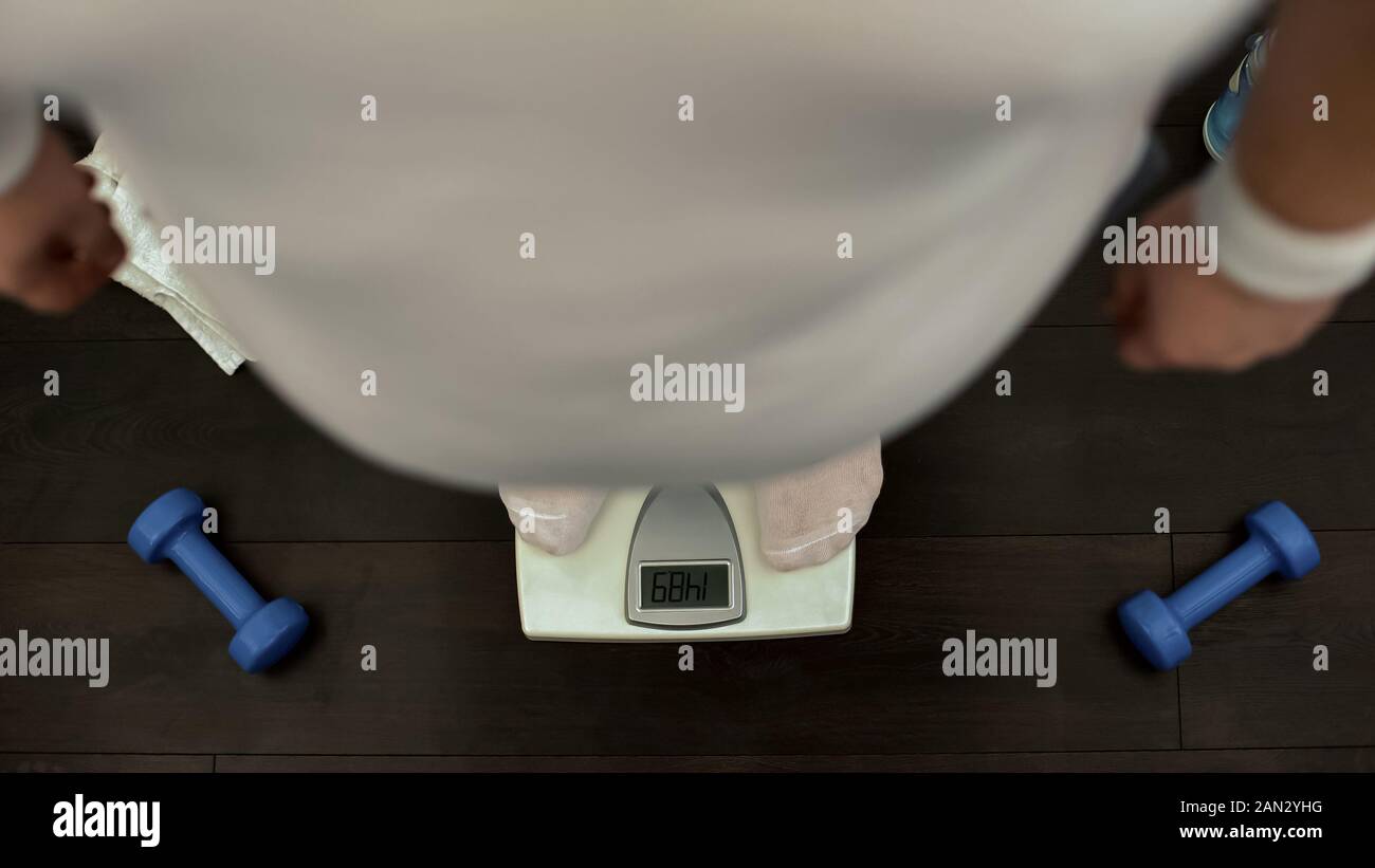 Overweight man standing on scale hi-res stock photography and images ...