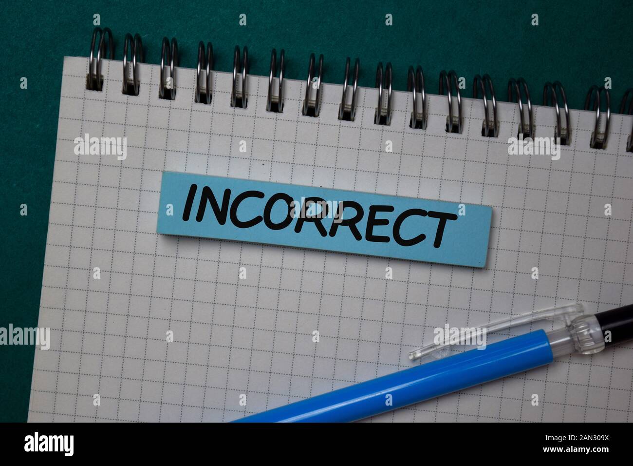 Incorrect write on a sticky note isolated on green background Stock ...