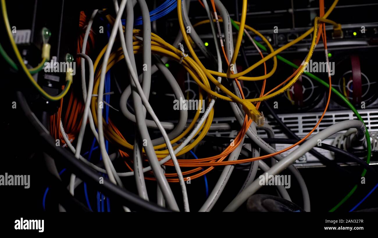 Tangled wires, power cables in datacenter, cabling mess in server room ... Tangled wires, power cables in datacenter, cabling mess in server room ...