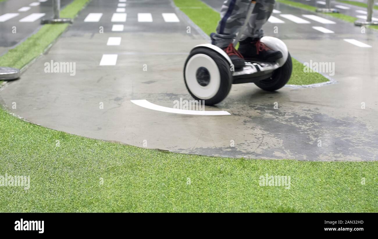 Boy driving personal transporter, active outdoors on two-wheeler ...