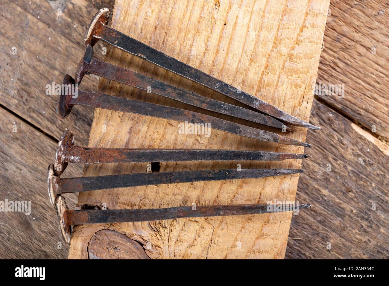 Old rusty nails on a workbench. Steel elements forged in old technology ...
