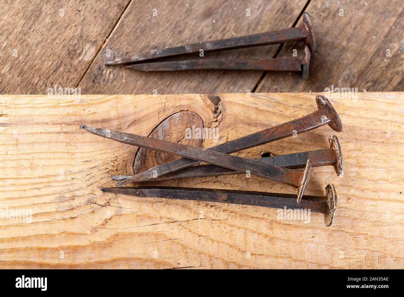 Old rusty nails on a workbench. Steel elements forged in old technology ...