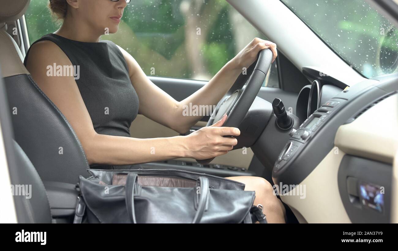 Serious business woman in luxury car driving on important meeting ...