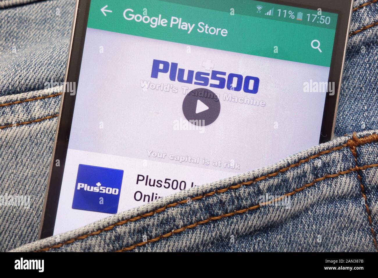 Plus500 app on Google Play Store website displayed on smartphone hidden ...