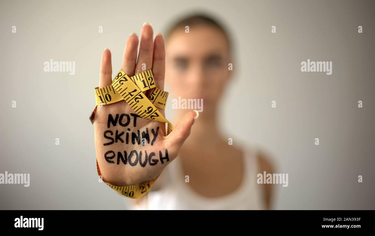 Not skinny enough written on woman palm with tape, severe diet ...