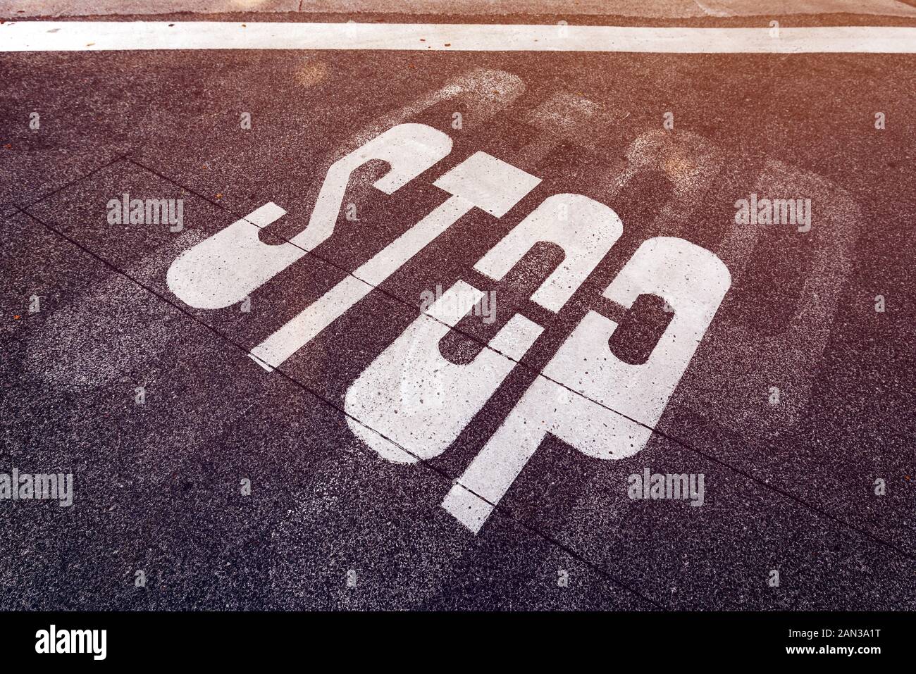 Stop road marking on asphalt roadway background Stock Photo - Alamy