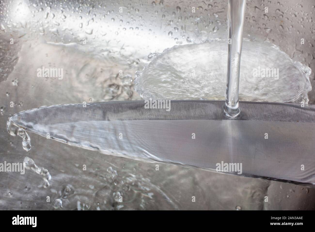 studio shot of cleaning a sharp knife with water over the sink Stock ...