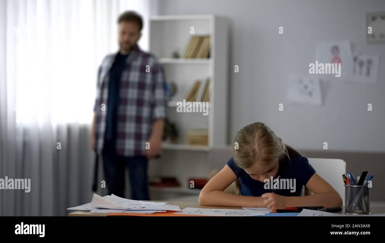 Father holding strap going to child, daughter doing homework ...
