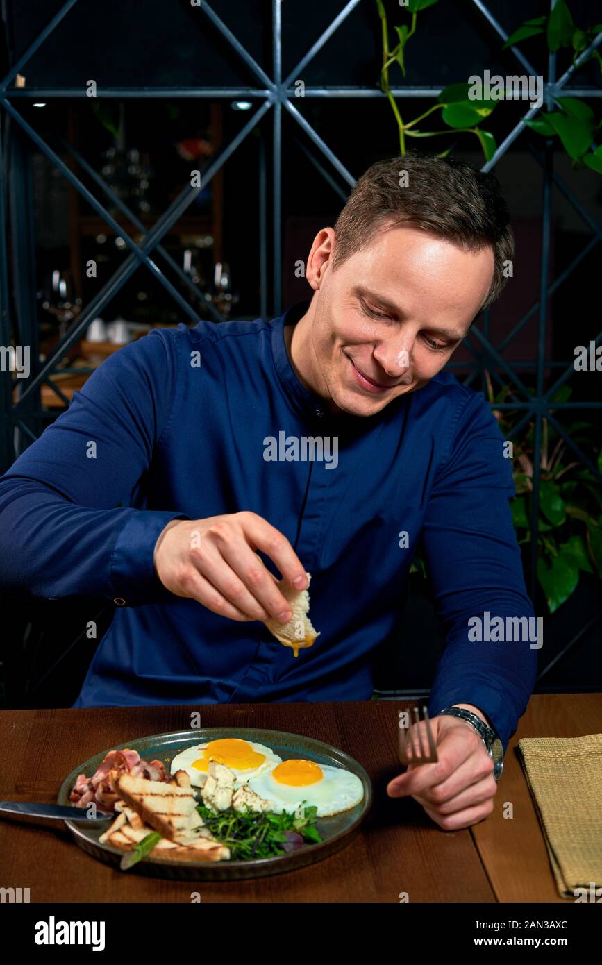 man eats eggs in a restaurant Stock Photo - Alamy