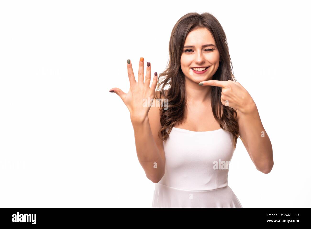 Portrait of young woman posing pointing to her hand without ring ...