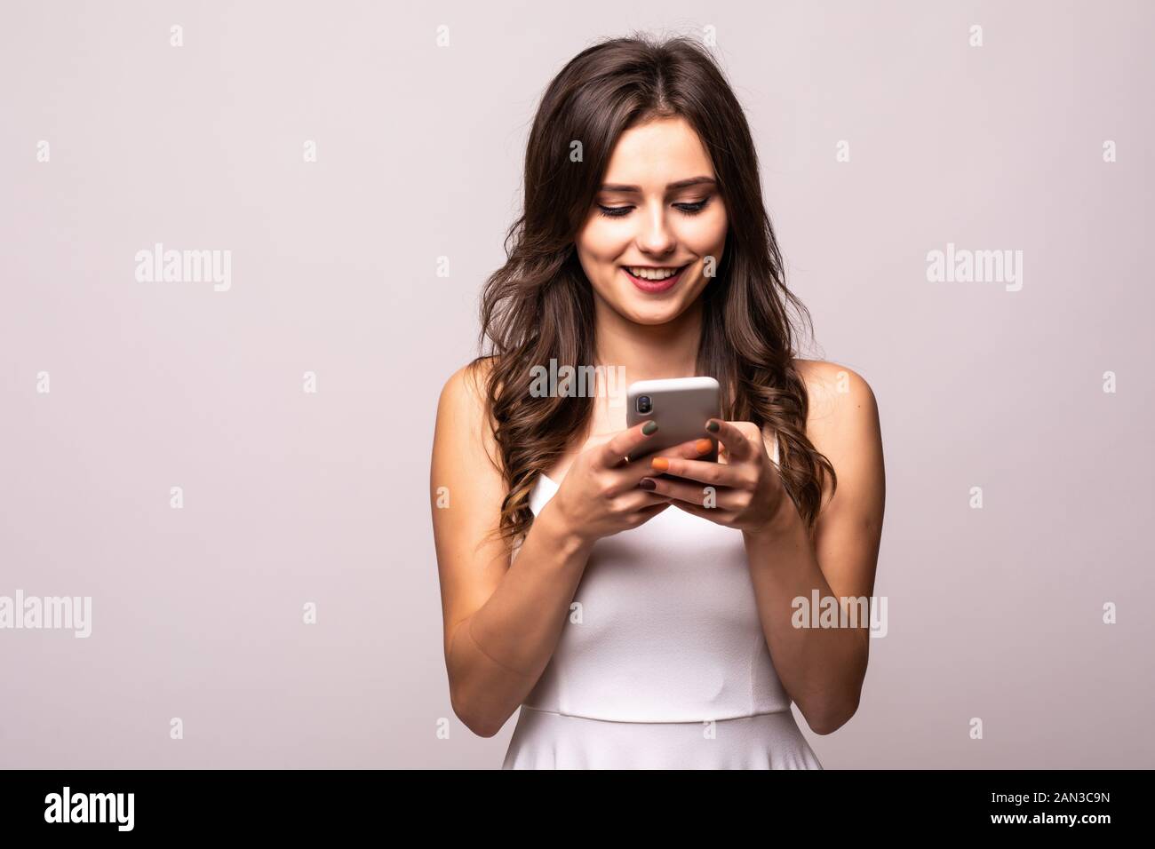 Woman texting on her mobile phone - isolated over a white background ...