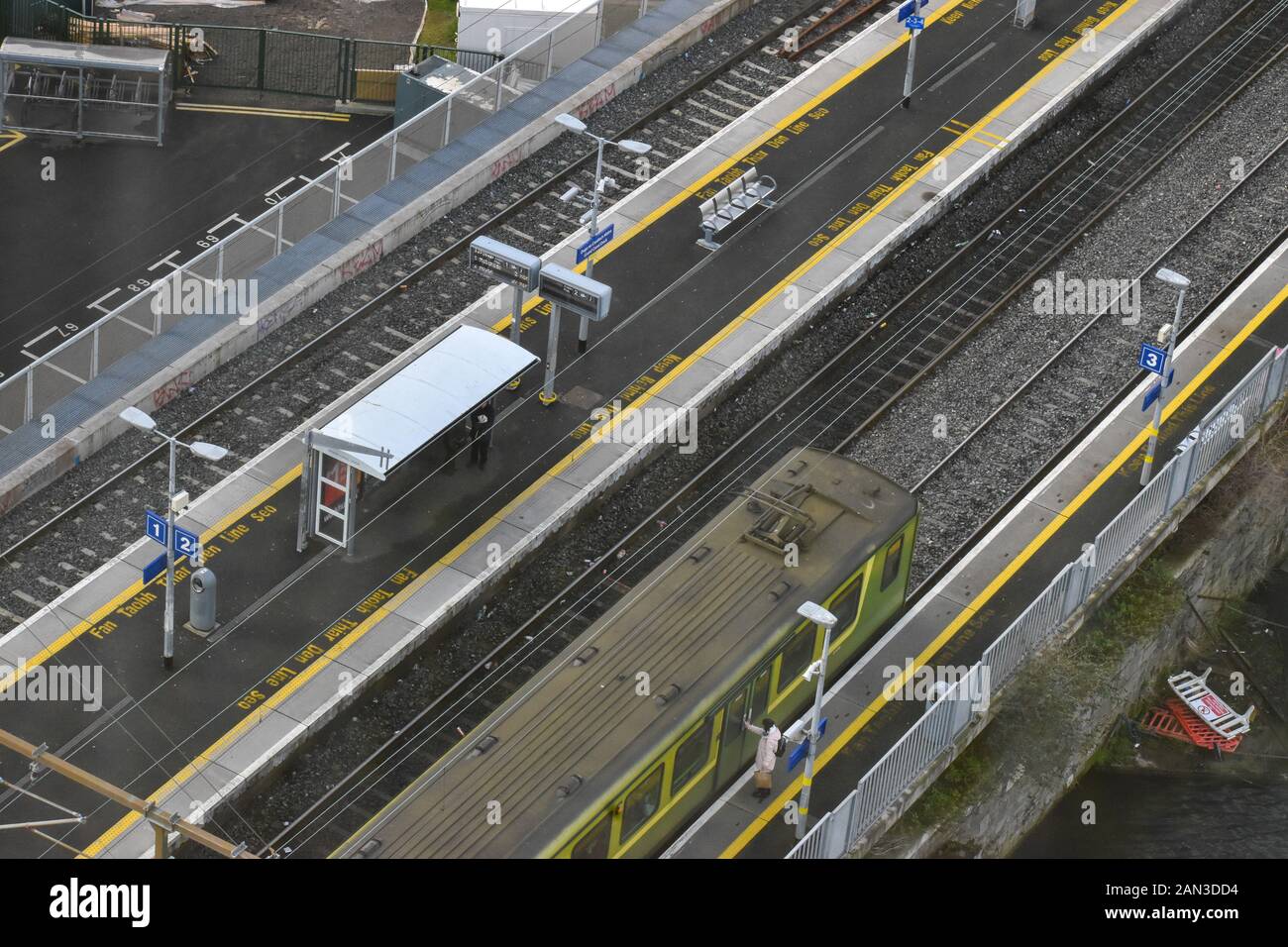 A birds eye view of a green train pulling into an empty station with ...