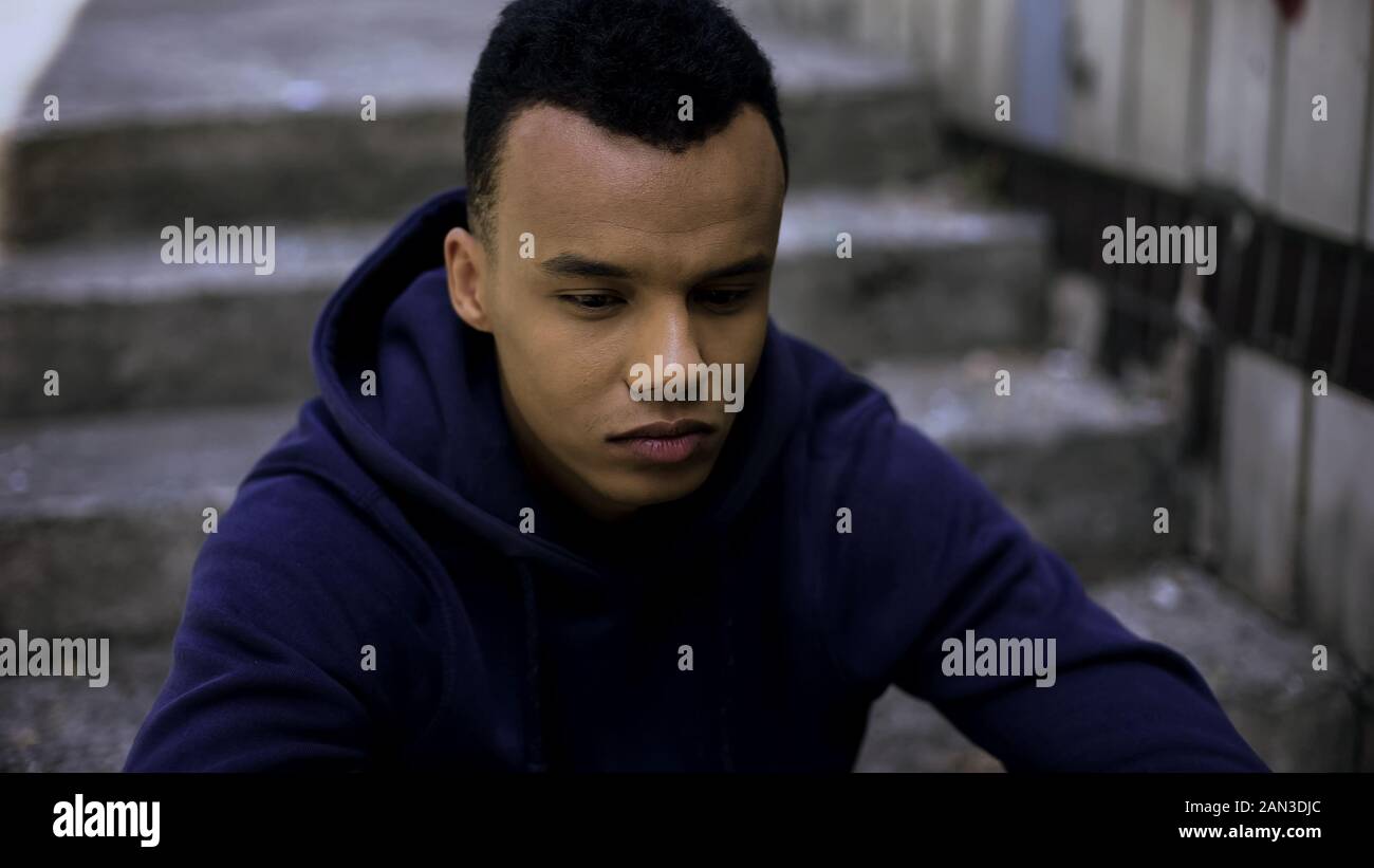 Hopeless afro-american teen sitting on steps in ghetto, concerned about ...