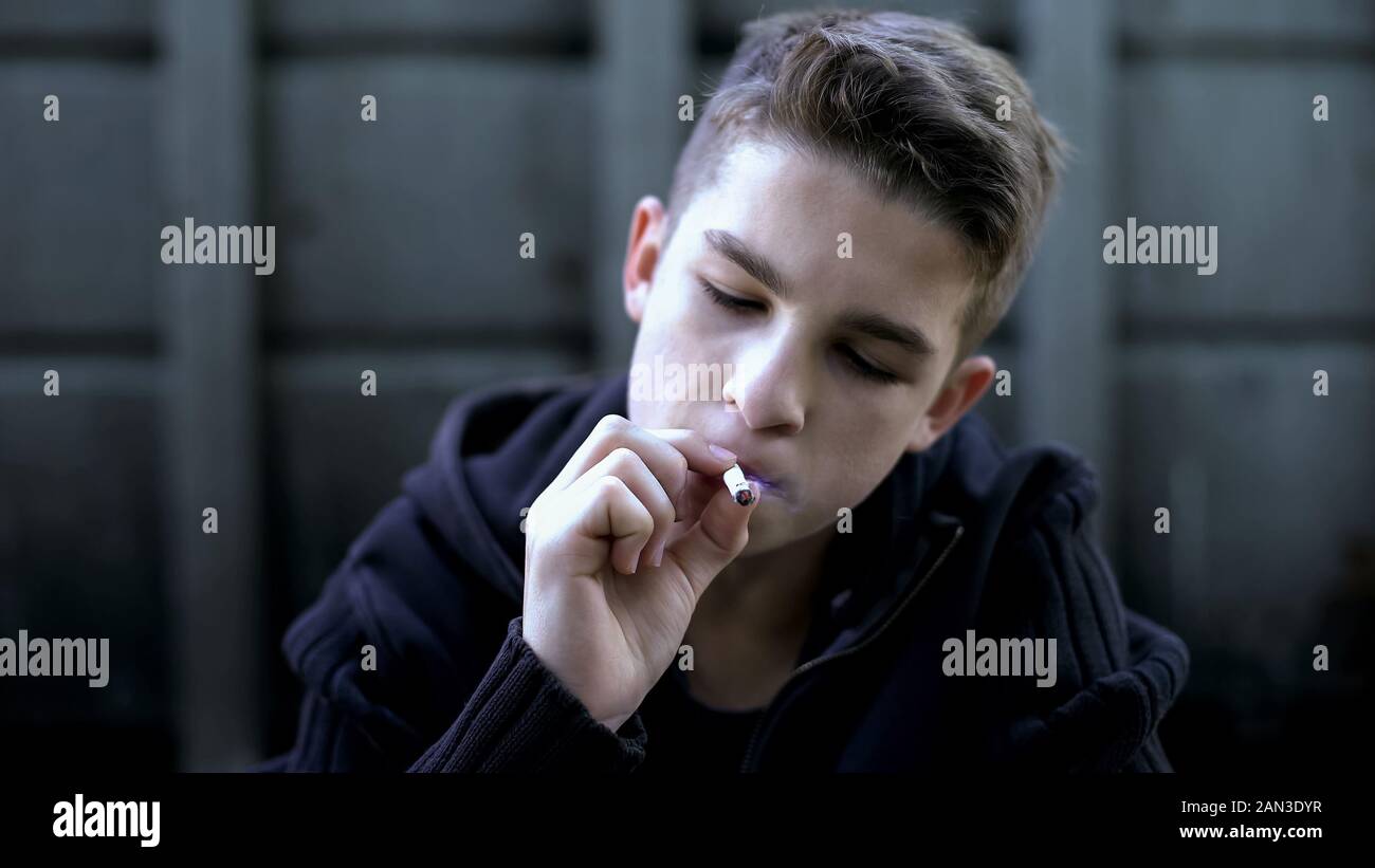 Teen boy smoking cigarette, health problems, lungs cancer risk, social ...