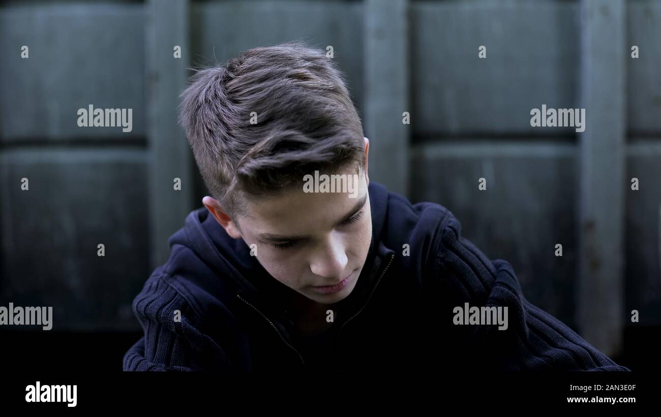 Depressed teenager boy feeling hopelessness, regretting wrong doings ...