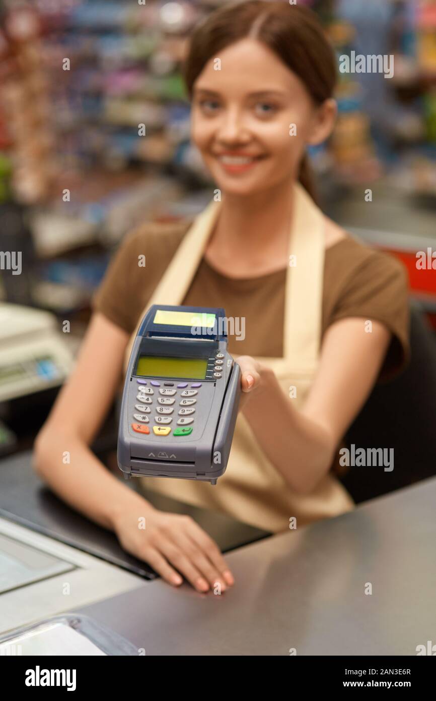 Daily Shopping. Young cashier woman at the supermarket offering credit ...