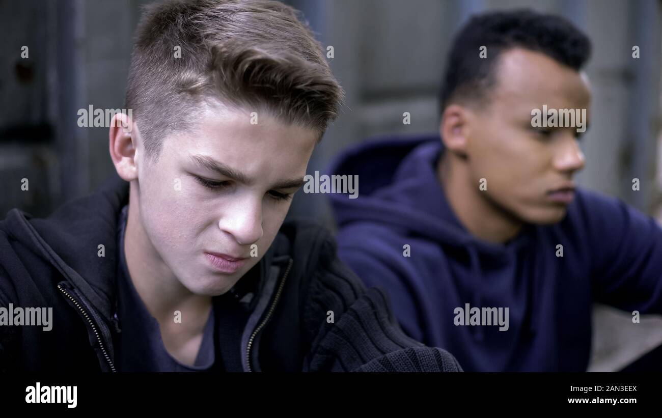 Two sad friends sitting in hideaway, became orphans, children of war ...