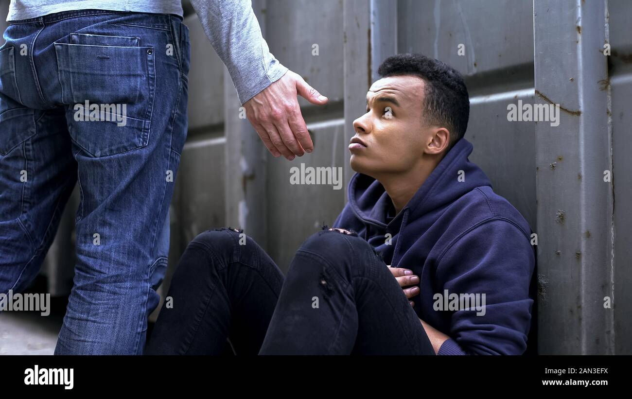 Passing by man offering helping hand to street child, kindness and ...