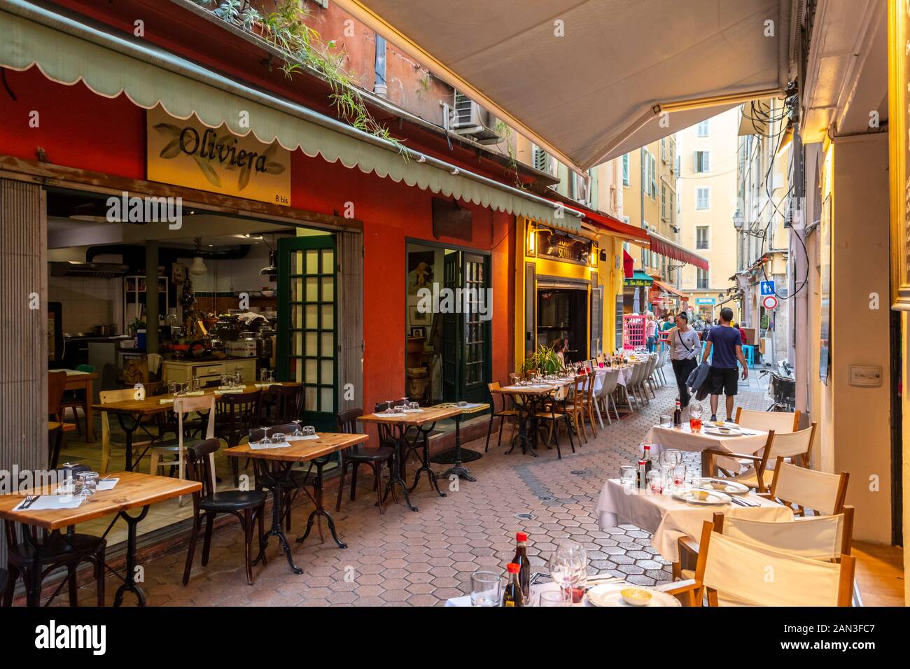 Tourists shop a very narrow alley full of cafes and shops in the Old ...