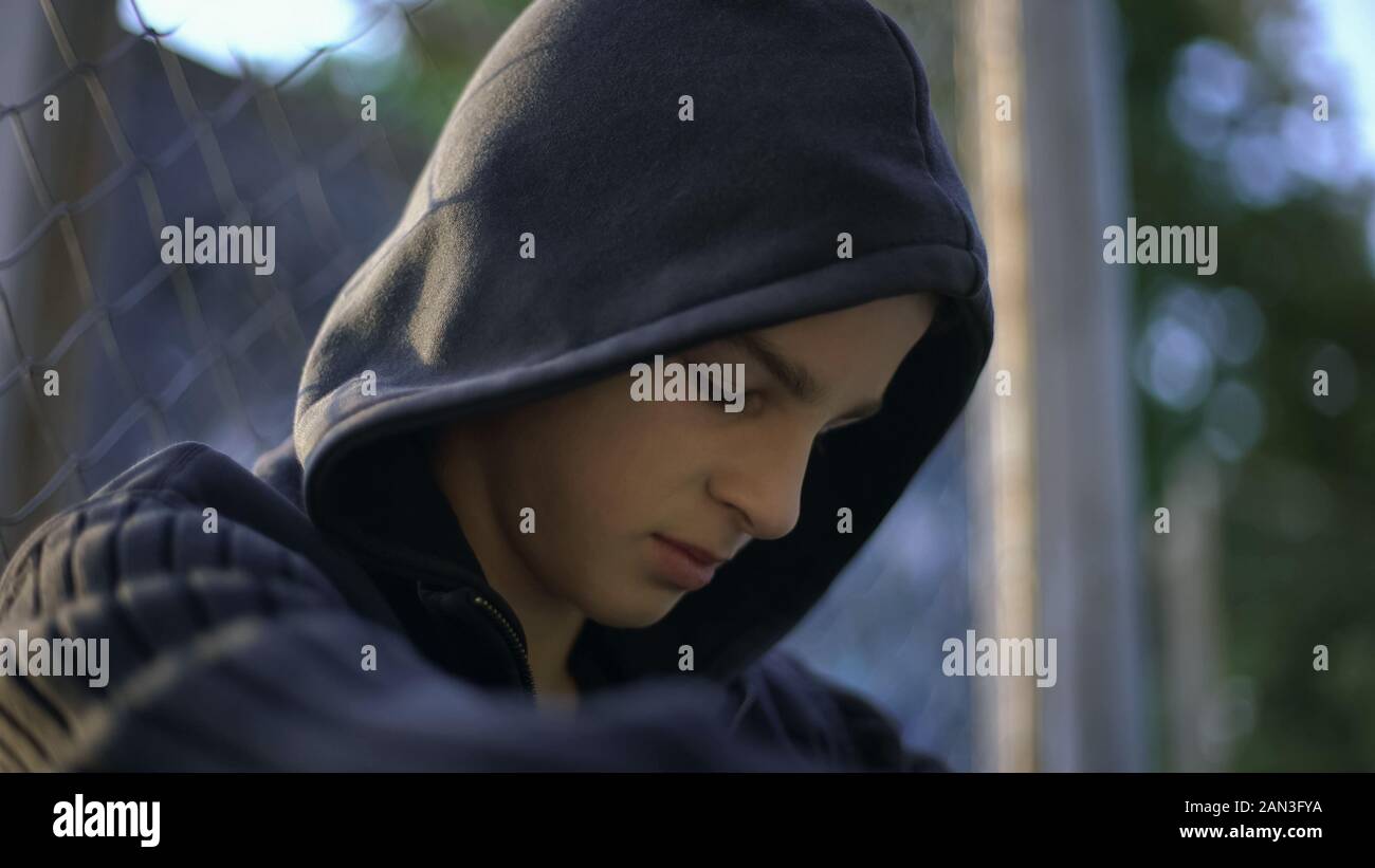 Teen guy feeling himself helpless, upset with bullying, hiding on ...