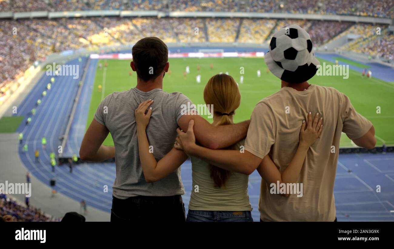 Football fans hugging at stadium, friends cheering victory of favorite ...