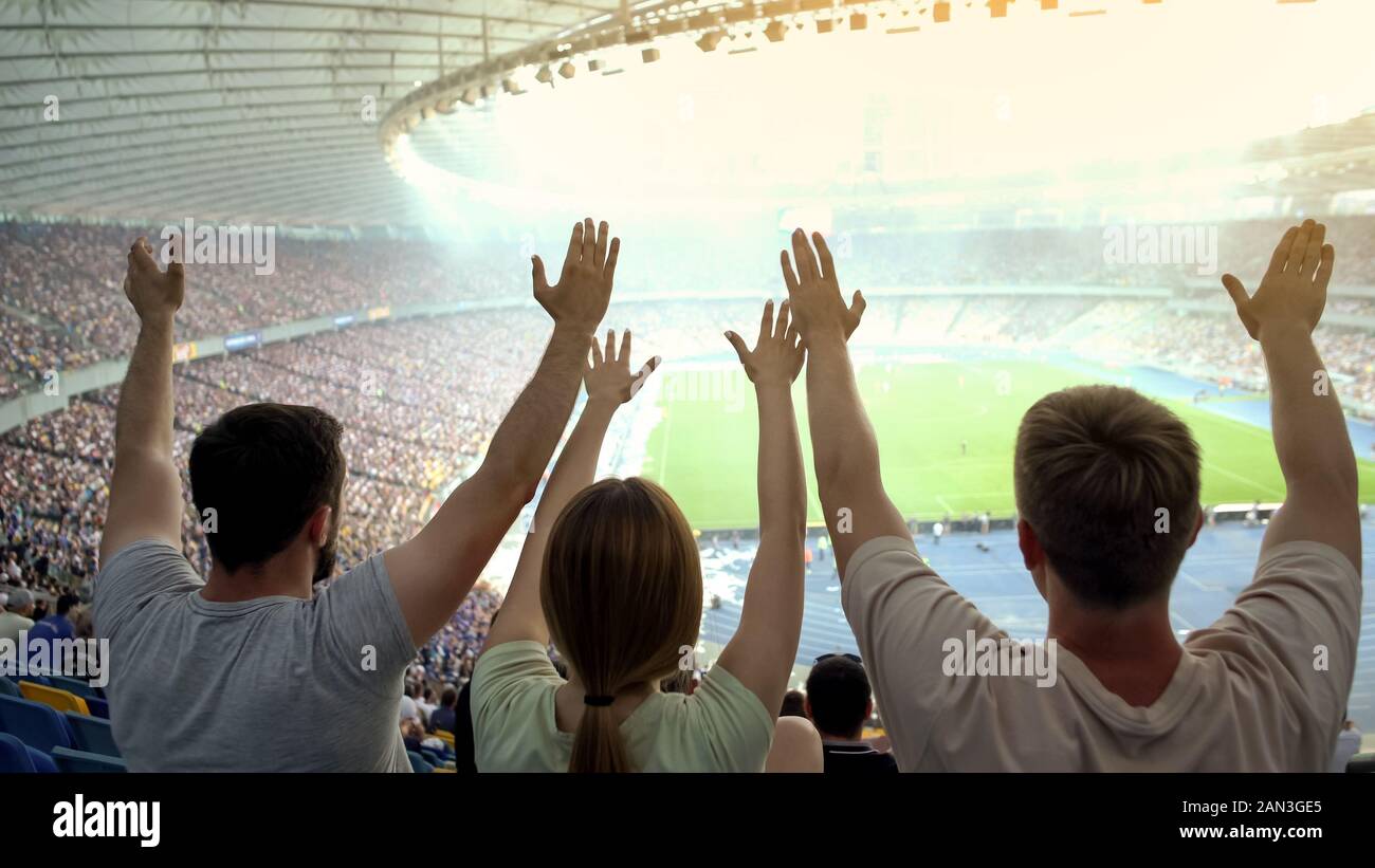 Young football fans with raised hands supporting national team during ...