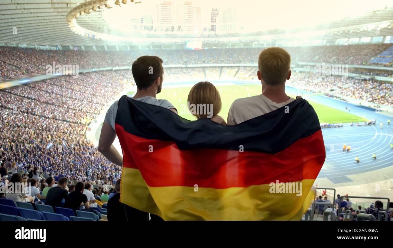 Football fans with German flag jumping at stadium, cheering for ...