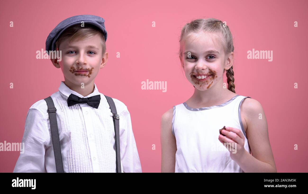 Funny children smiling and eating chocolate candies, celebrating ...