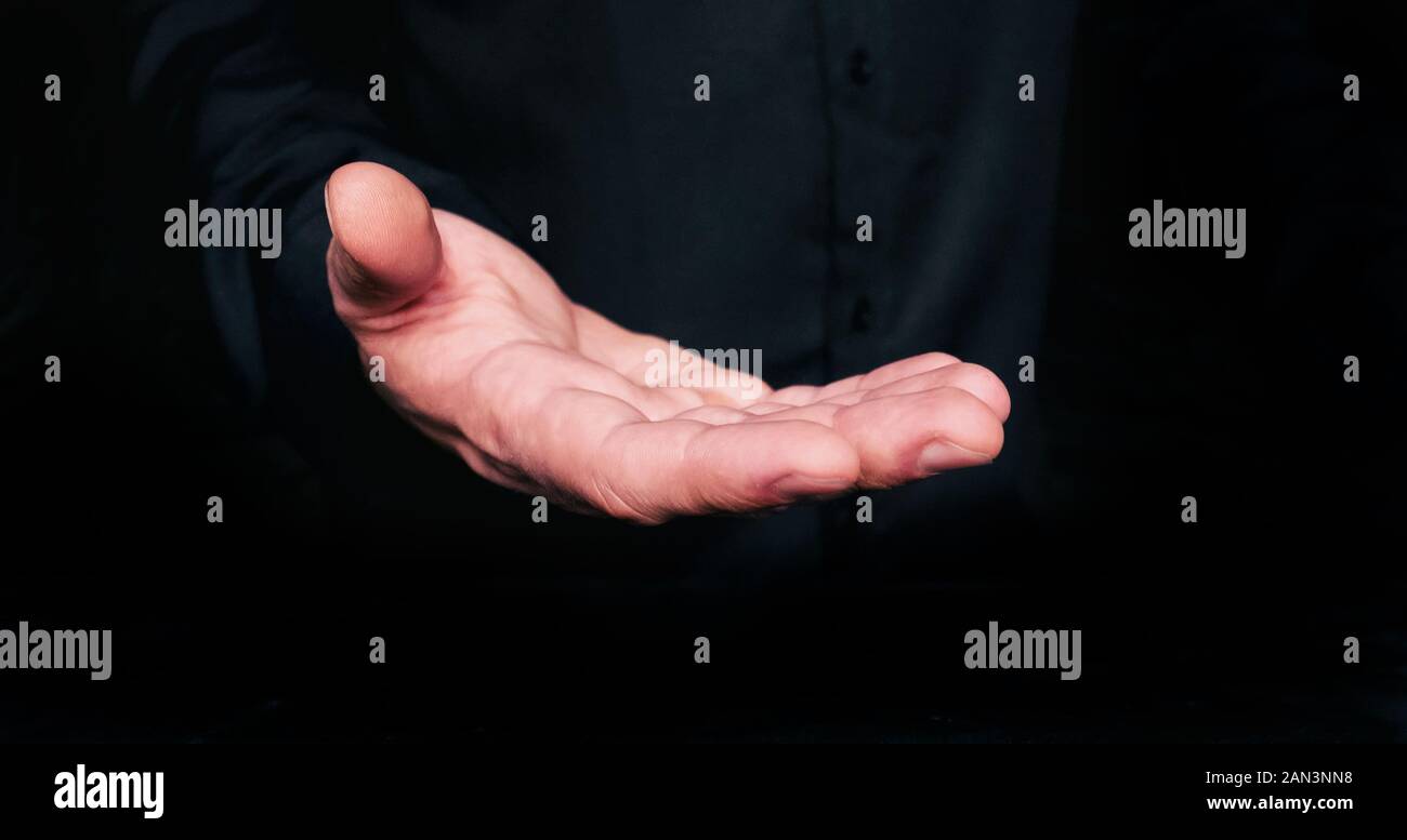 Open male hand. The man gives a hand. Palm on a black background. Blank ...