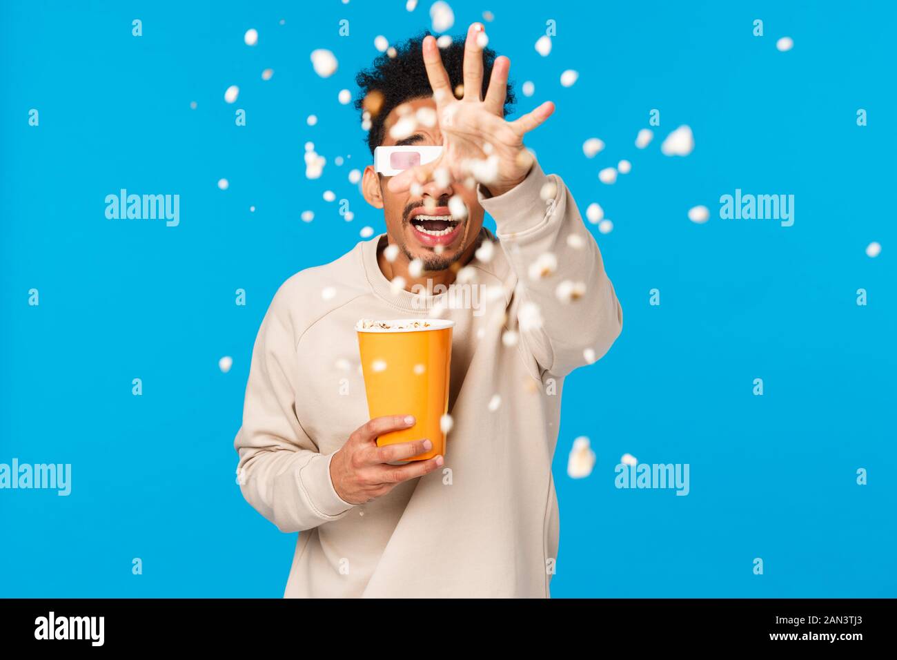 Scared and shocked young man watching 3d horror movie and throwing ...