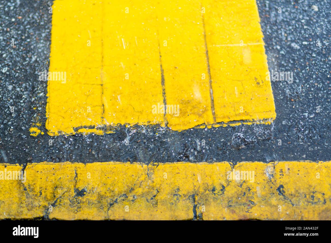 Road markings in yellow paint on black asphalt Stock Photo - Alamy