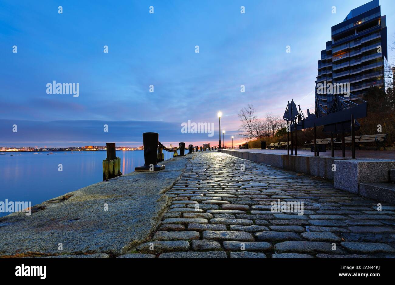 Boston Harbor before sunrise. Photo shows Fan Pier Park cobblestone ...