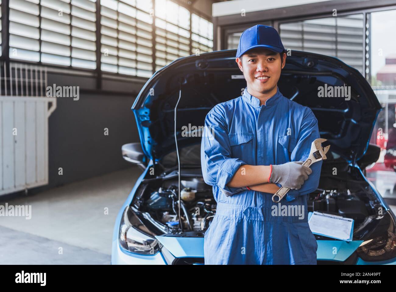 Happy car mechanic inspection technician holding wrench and smiling to ...