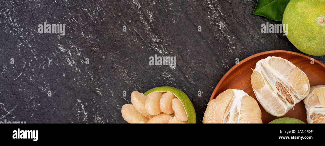 Fresh peeled pomelo, pummelo, grapefruit, shaddock on dark background ...