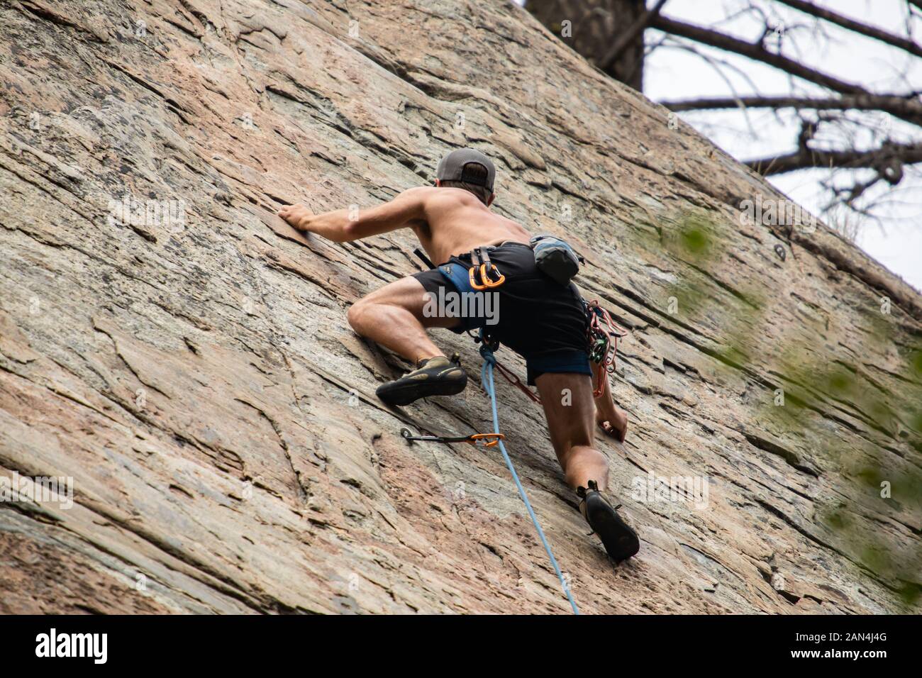 A low angle view of a muscular man during a rock climbing expedition ...